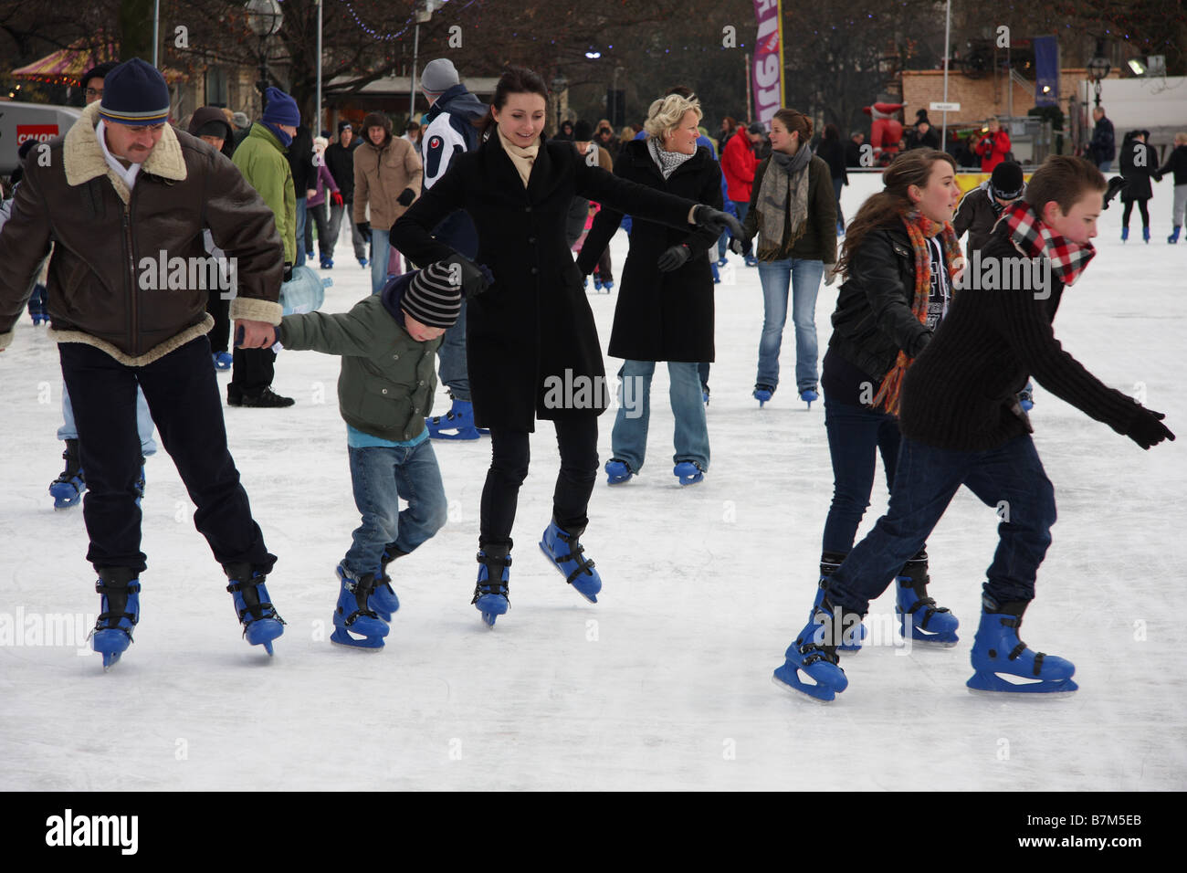 family children people ice skating skaters rink open air cold winter ...