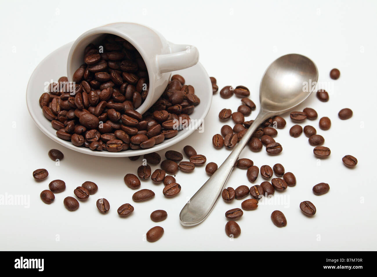 Coffee beans spilled cup spoon saucer on white background Stock Photo ...