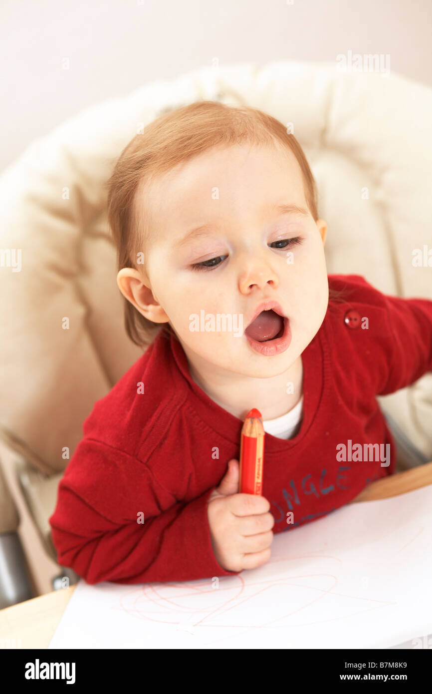 Child drawing. Sitting in a kids chair at the table Stock Photo - Alamy