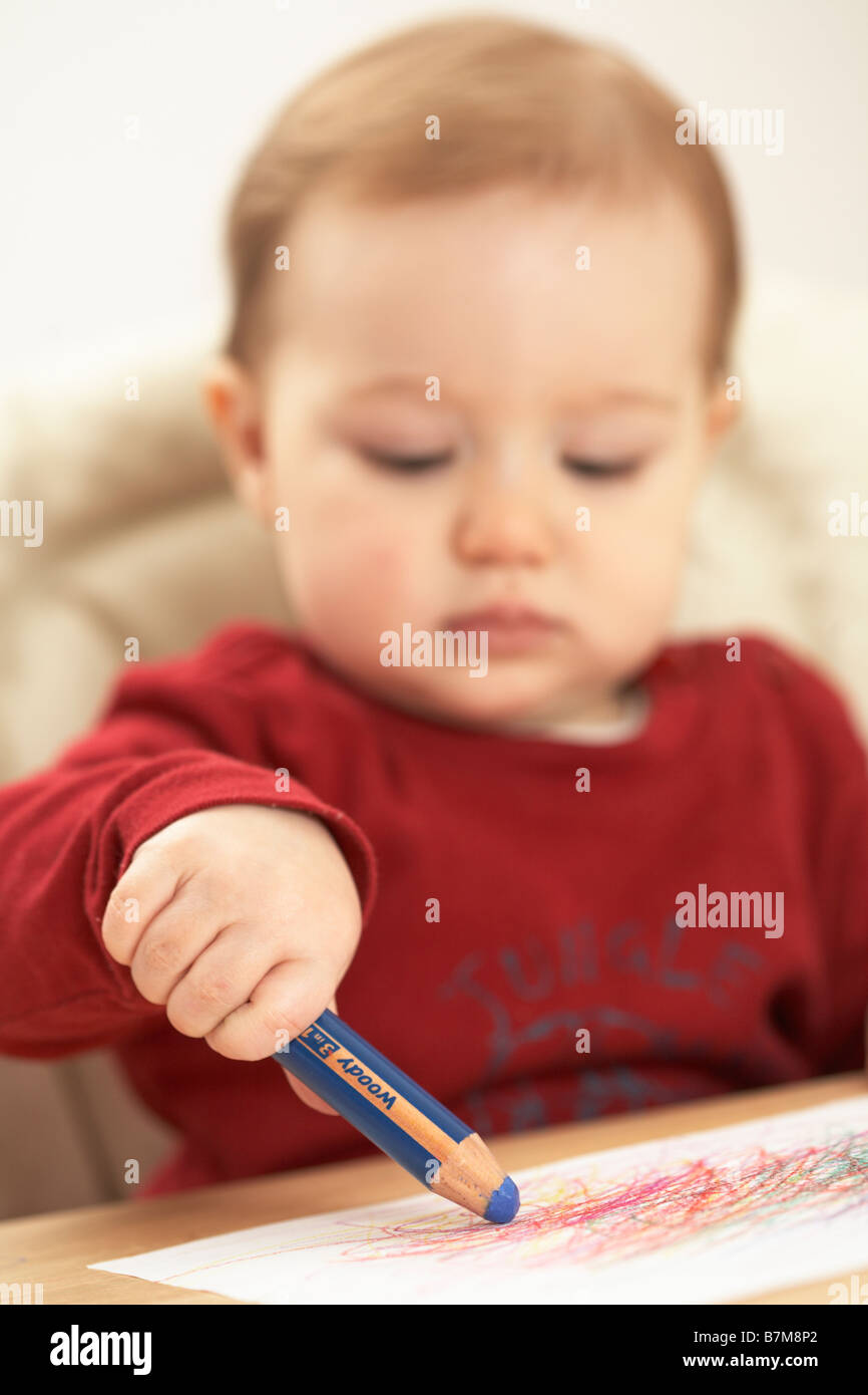 Child drawing. Sitting in a kids chair at the table Stock Photo - Alamy