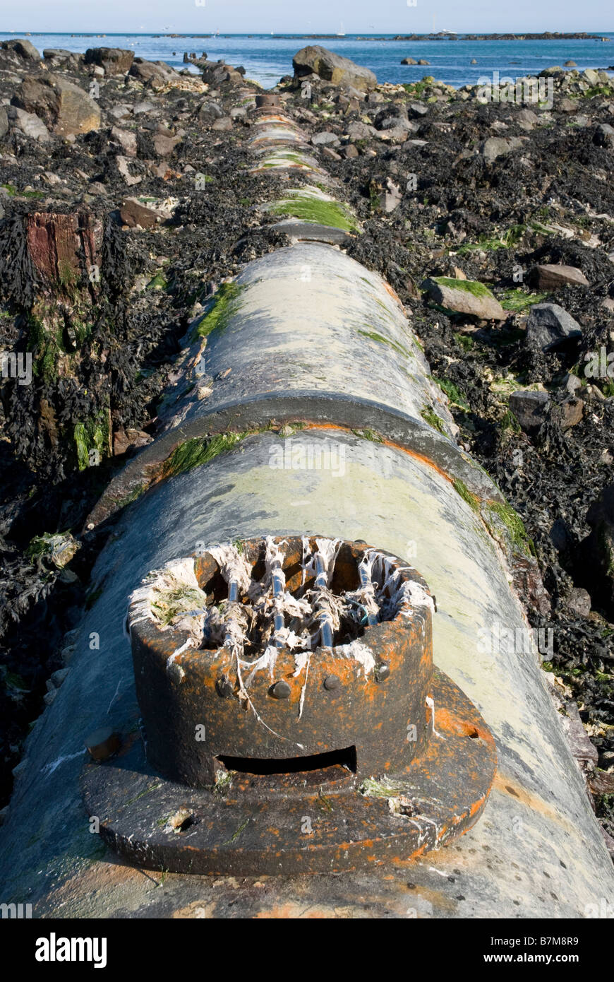 Raw sewage outfall pipe on rocky beach going into the sea, including ...