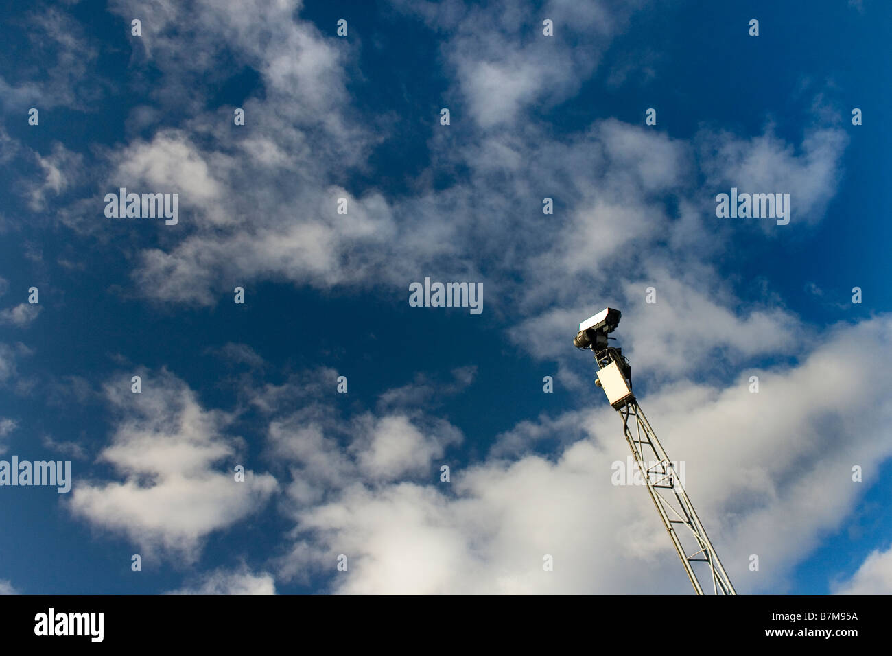 Looking up at a cctv camera in a blue sky Stock Photo - Alamy