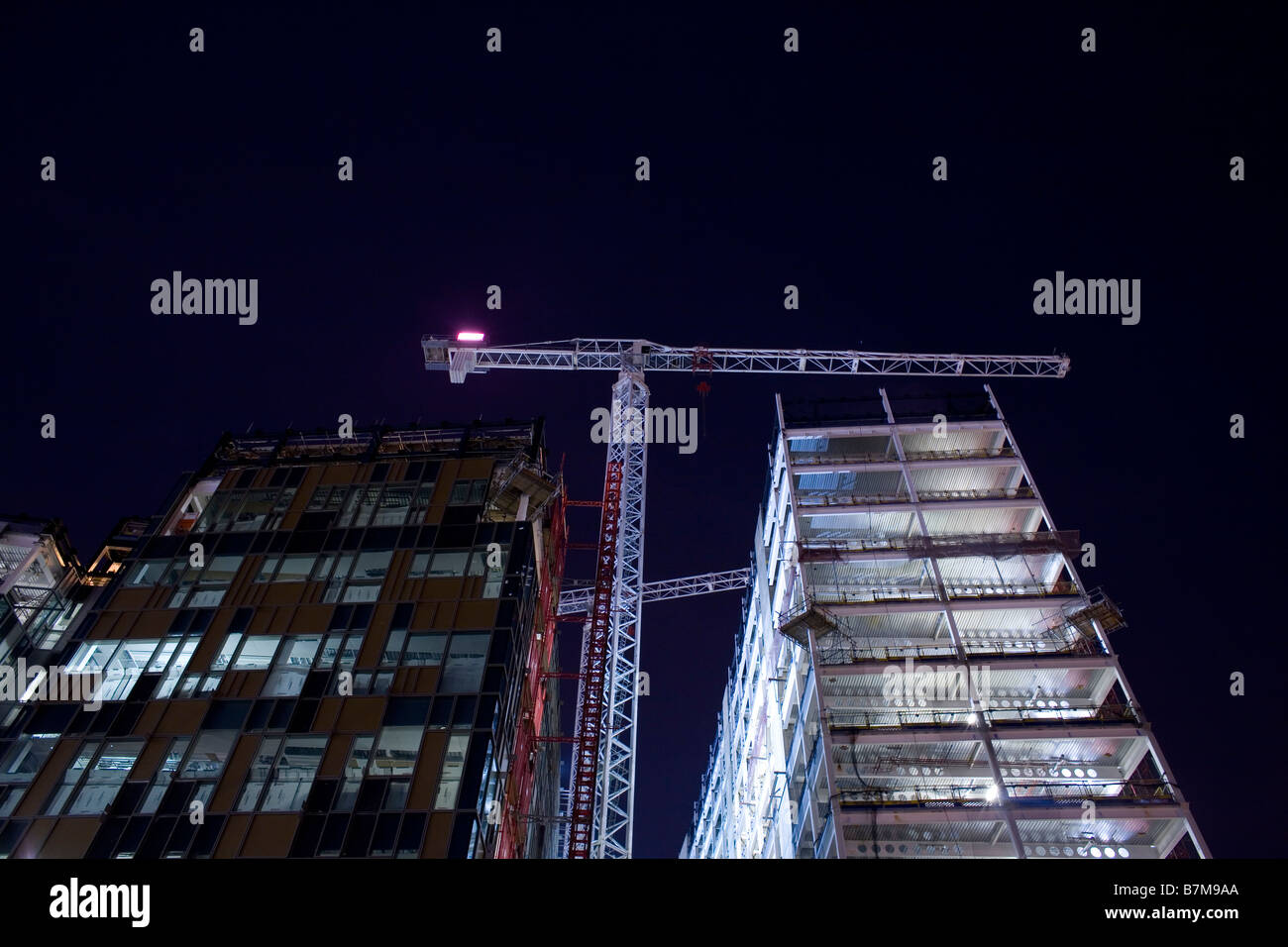 A crane stands tall between two buildings on a construction site at ...
