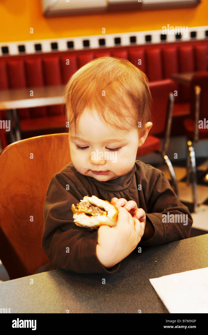 Child (15 month) old eating first Hamburger ever in a Hamburger ...
