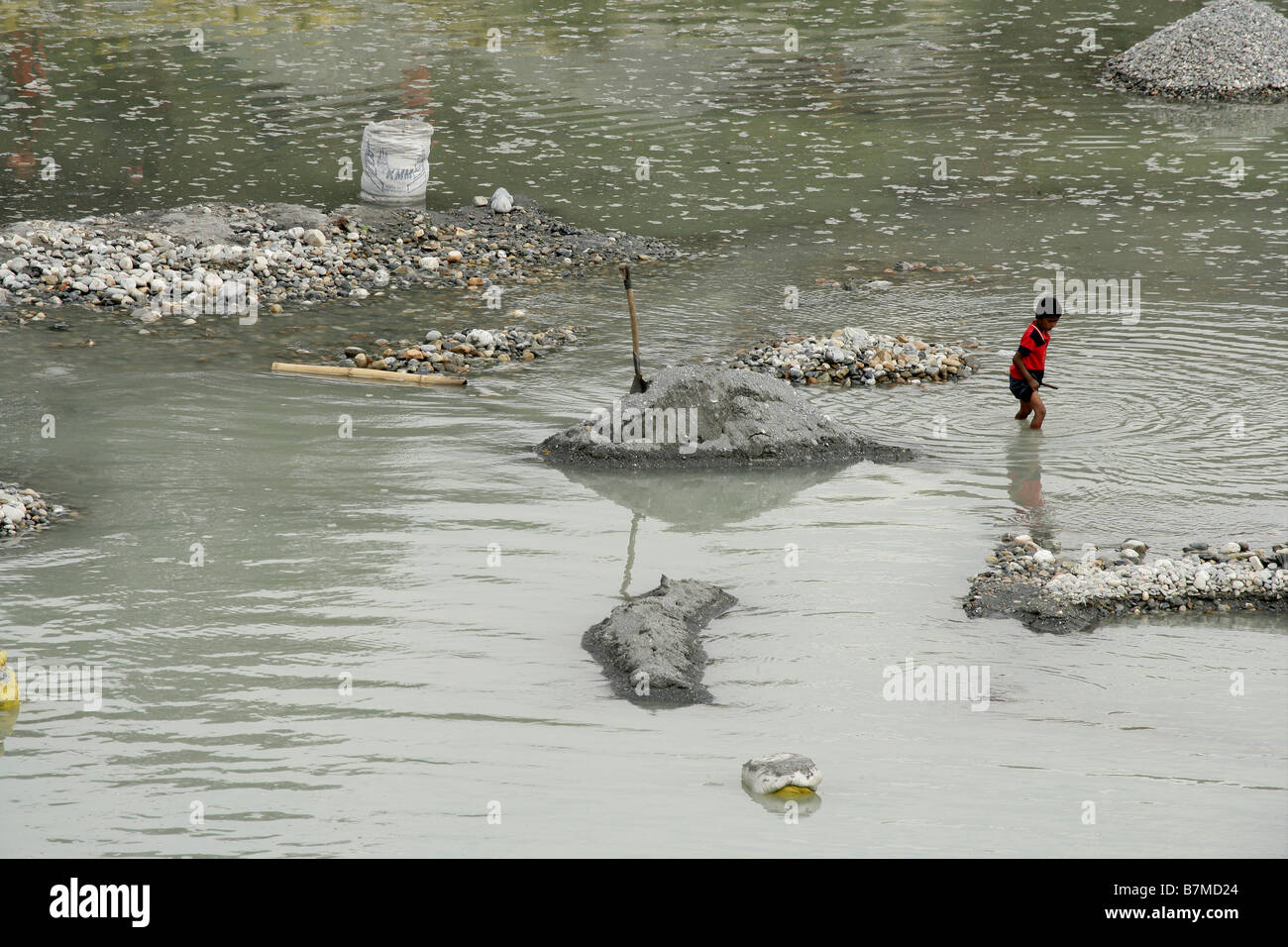 Boy playing in a rising river Stock Photo - Alamy