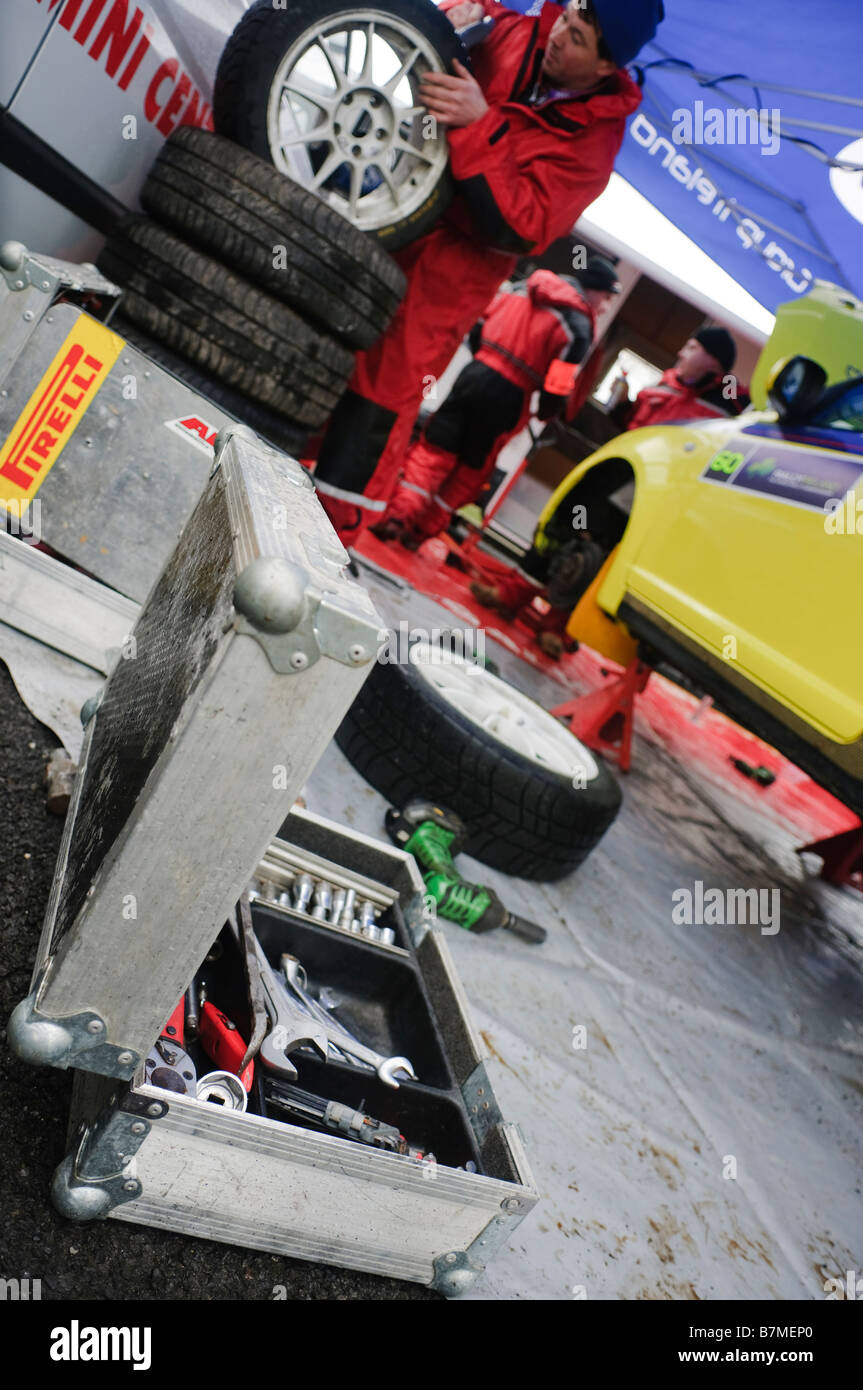 Toolbox with rally car mechanic retreading a tyre behind at Rally ...