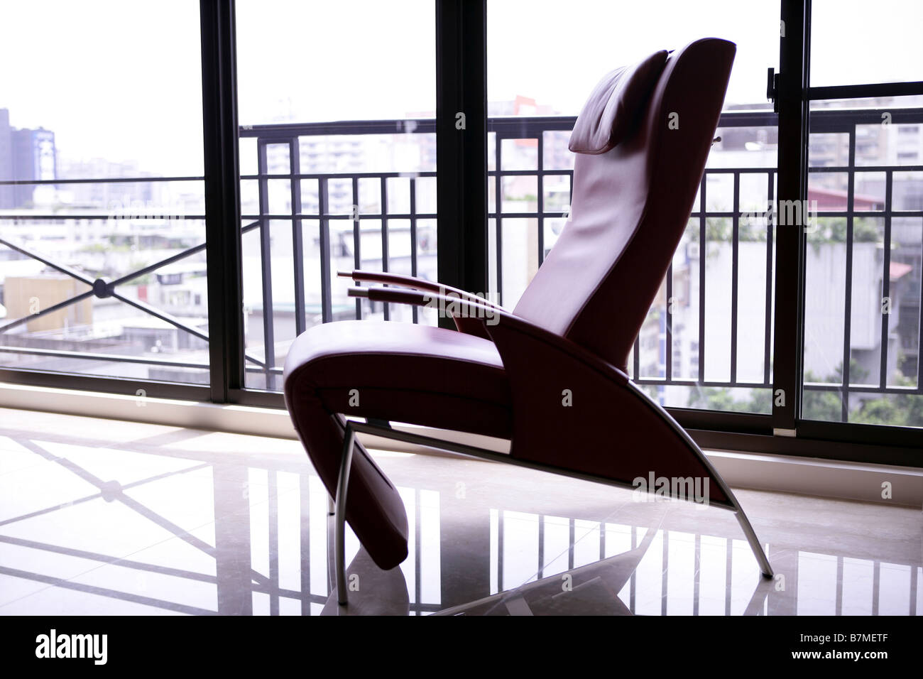 Side view of a stylish chair placing by window Stock Photo - Alamy