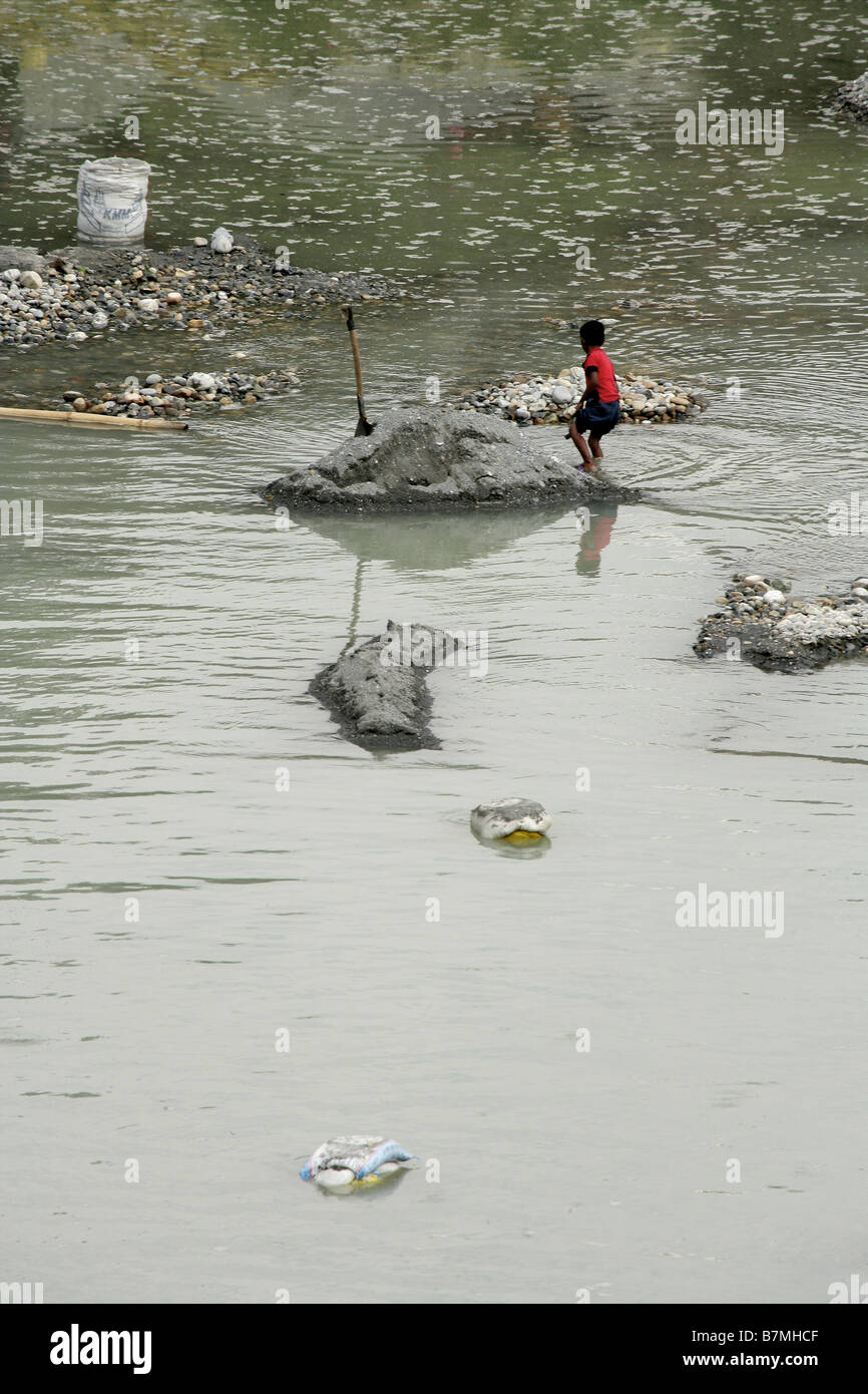 Boy playing in a rising river Stock Photo - Alamy
