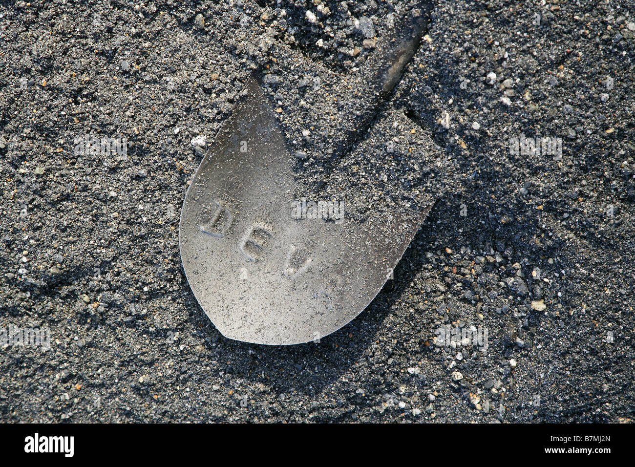 Spade in sand Stock Photo - Alamy