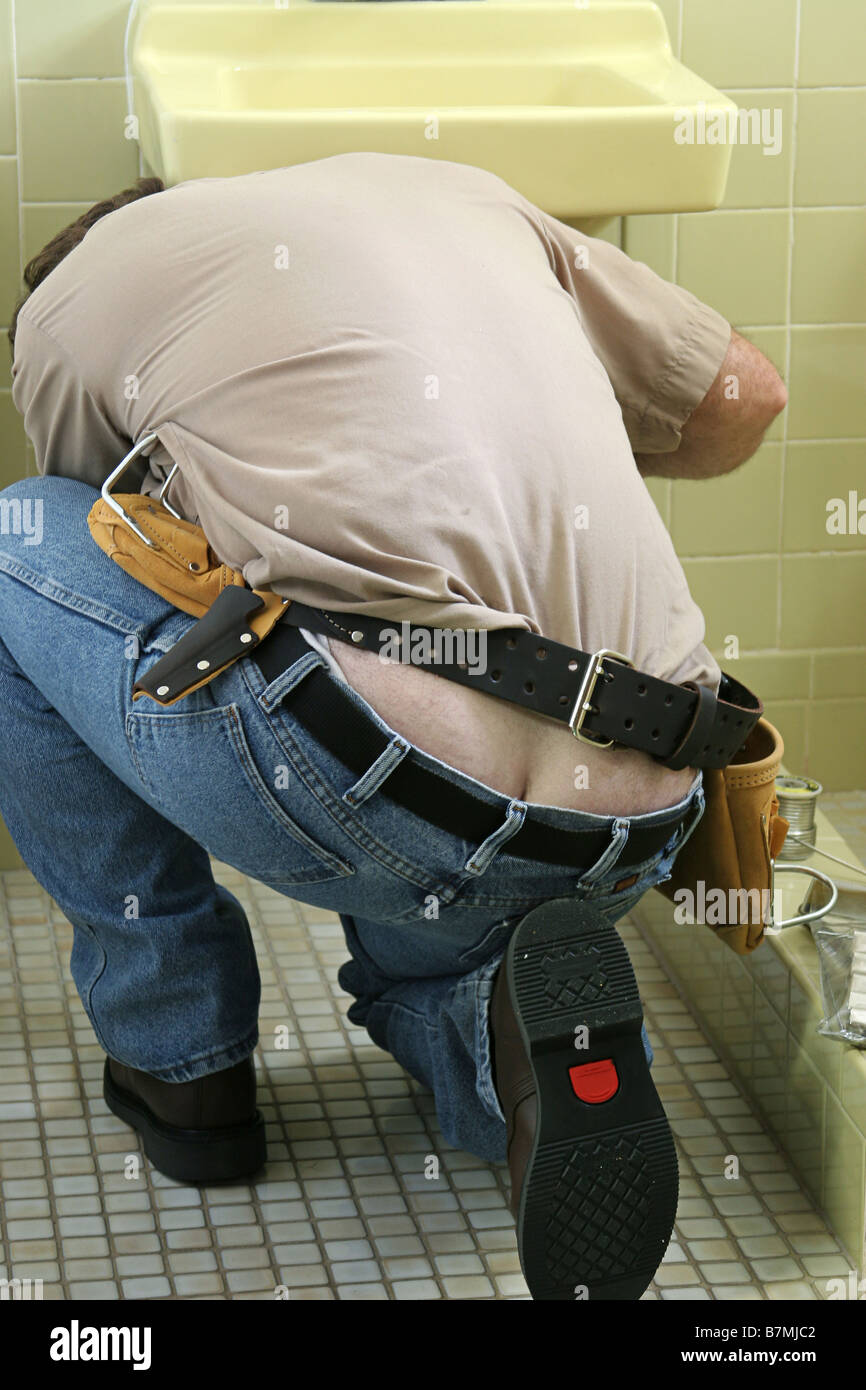 A Plumber Bending Over To Fix A Sink His Butt Crack Is Showing Stock