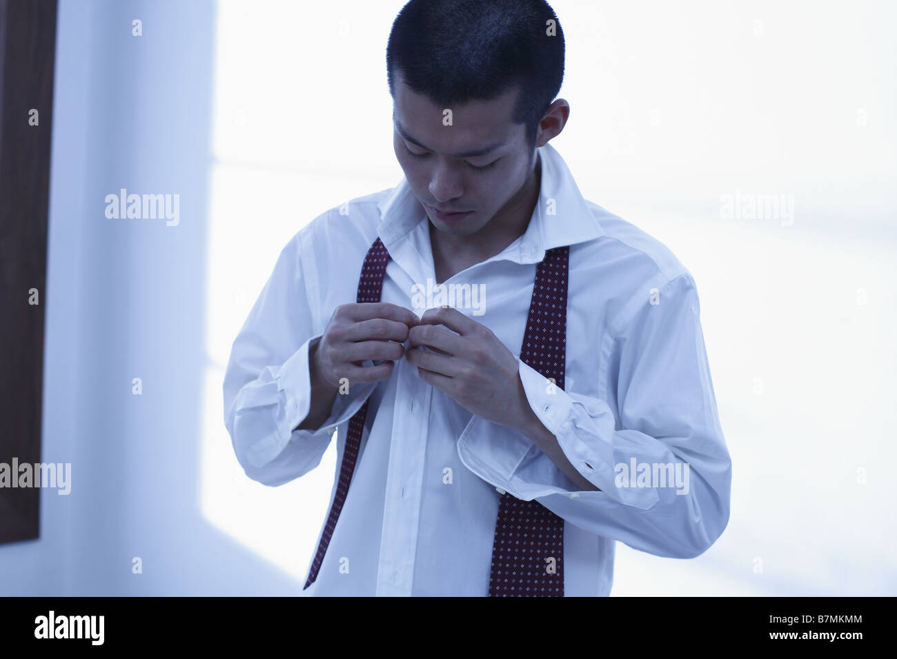 Man Buttoning Shirt Stock Photo - Alamy