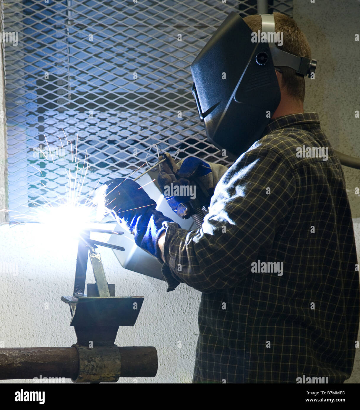 Welder at work illuminated by an acetylene welding torch All work ...