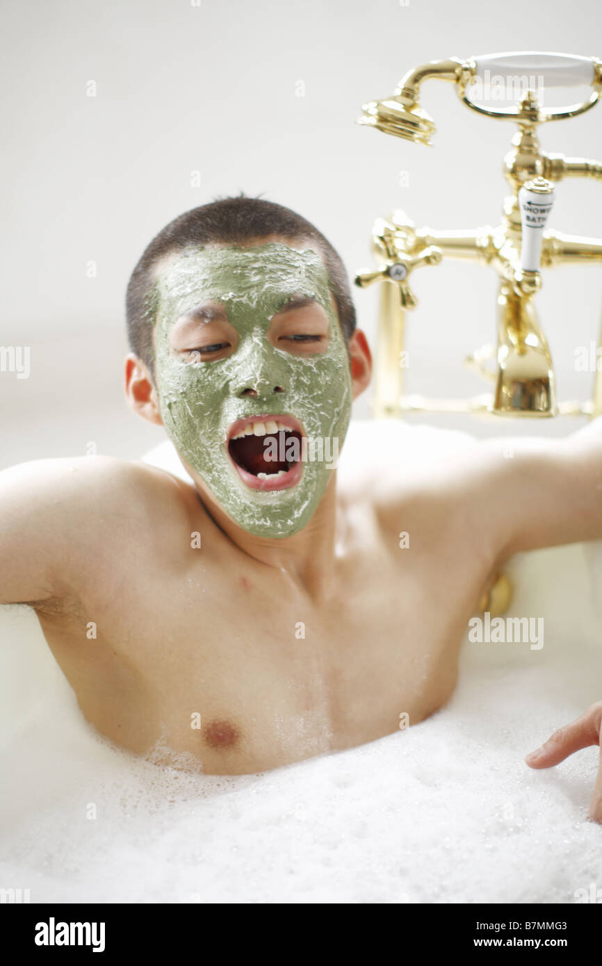 Man Relaxing in a Bathtub with a Facial Mask Stock Photo - Alamy