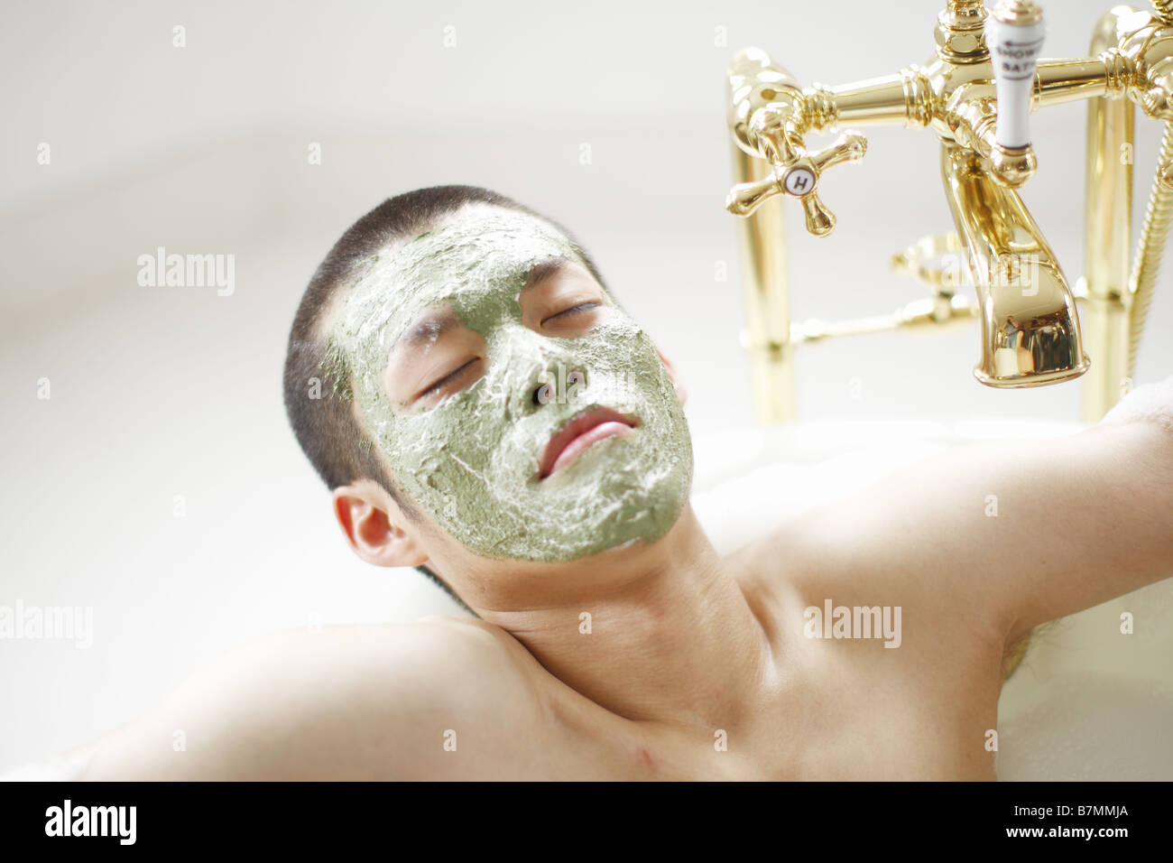 Man Relaxing in a Bathtub with a Facial Mask Stock Photo - Alamy