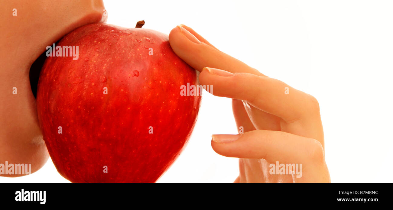 Beautiful young woman eating red apple over white Stock Photo - Alamy