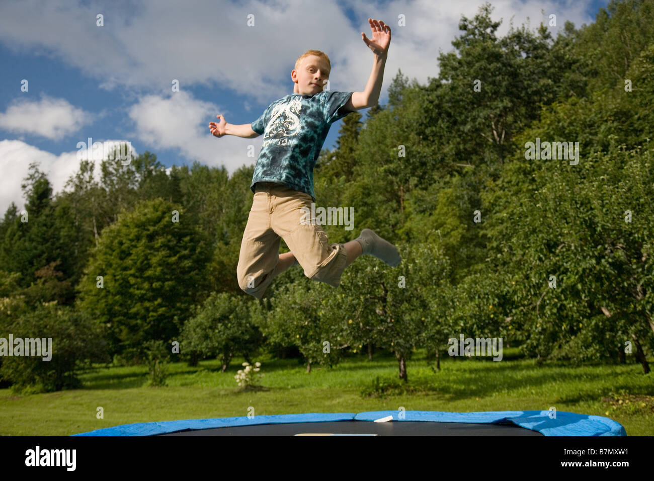 Teenage Boy Jumping on Trampoline Stock Photo - Alamy