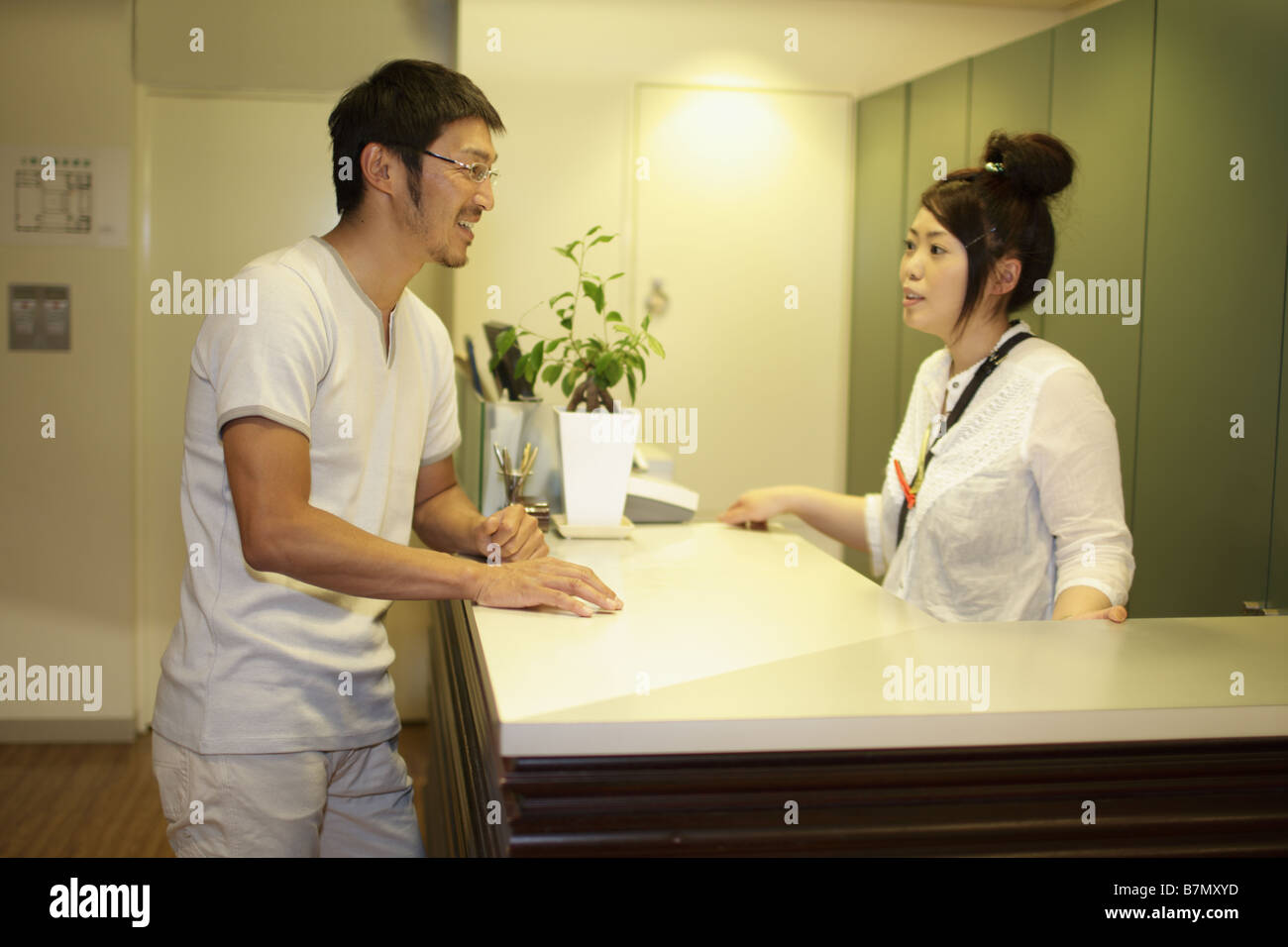Receptionist and Man Standing at Reception Desk in Hairsalon Stock ...