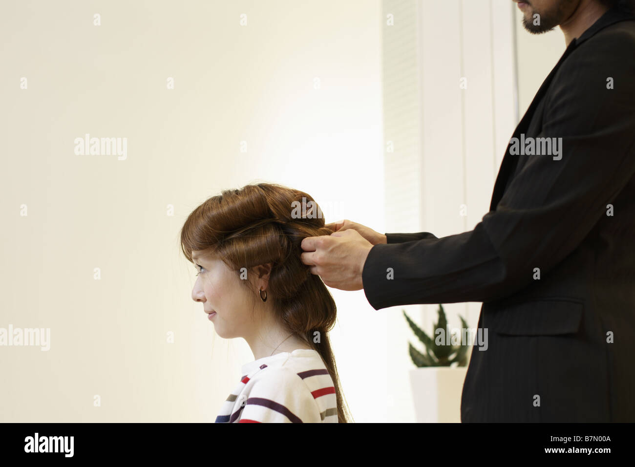 Hairdresser Putting Curlers in Woman's Hair Stock Photo - Alamy