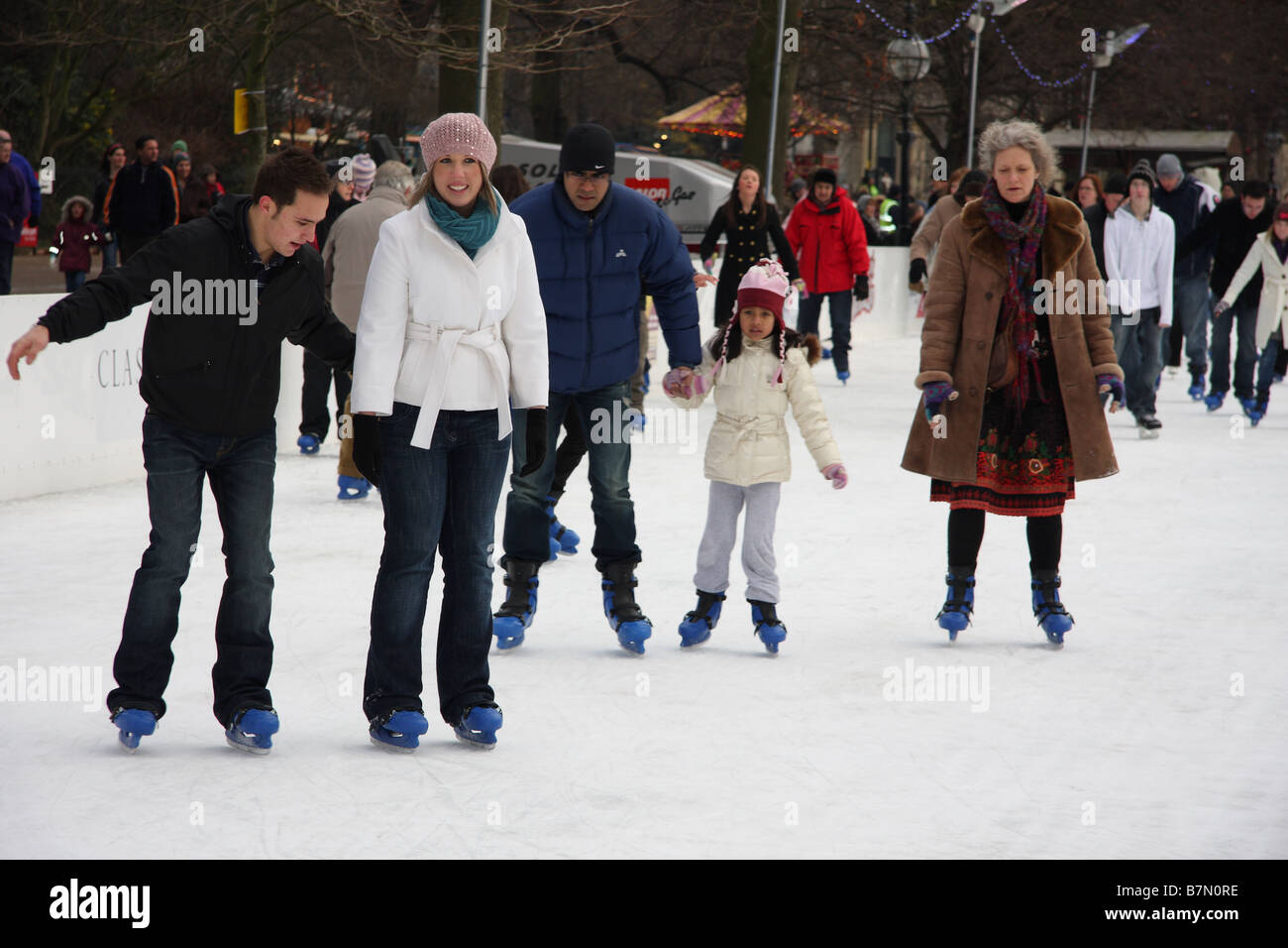 family children people ice skating skaters rink open air cold winter ...
