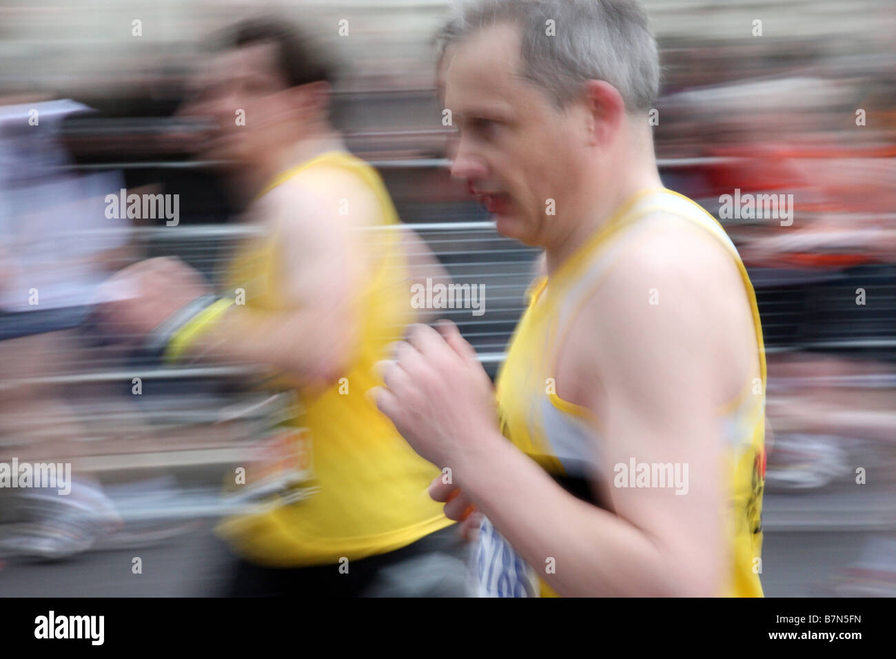 Two men running the London Marathon at Embankment. They are blurred to ...