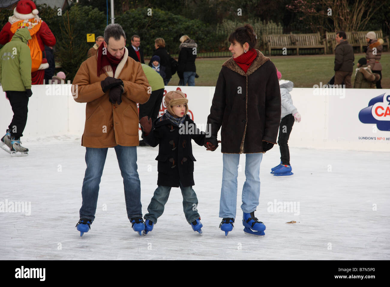 family children people ice skating skaters rink open air cold winter ...