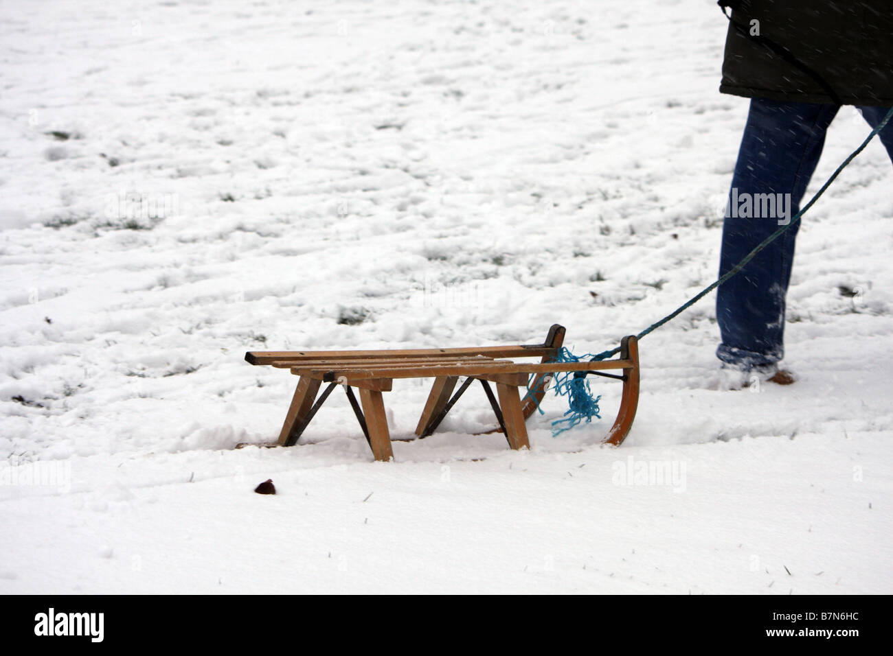 Pulling a wooden sledge through the snow Stock Photo - Alamy