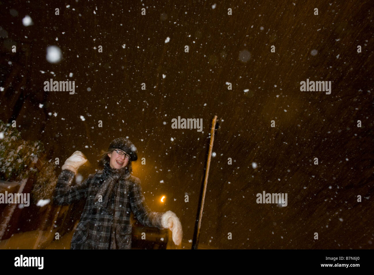 A girl plays snowballs at night during heavy snow showers in central ...