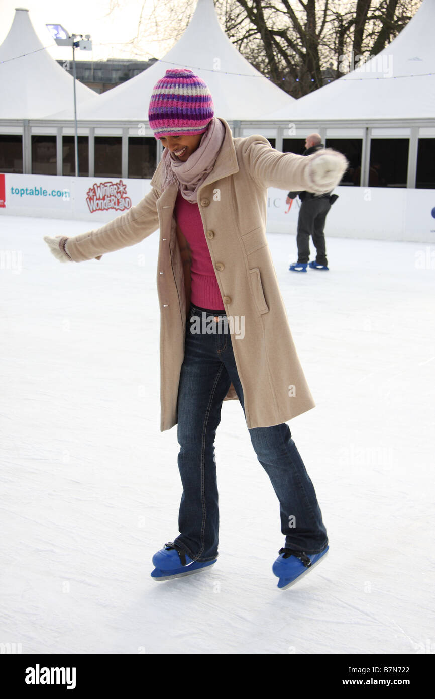 ethnic black happy teenage girl ice skating rink open air cold winter ...