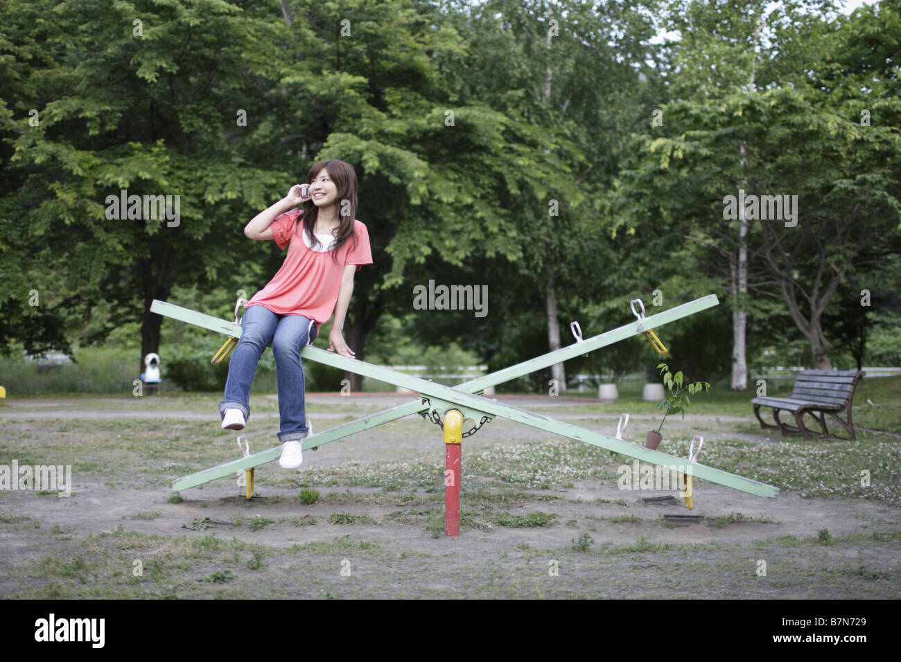 Woman On Phone Sitting On Seesaw Stock Photo - Alamy