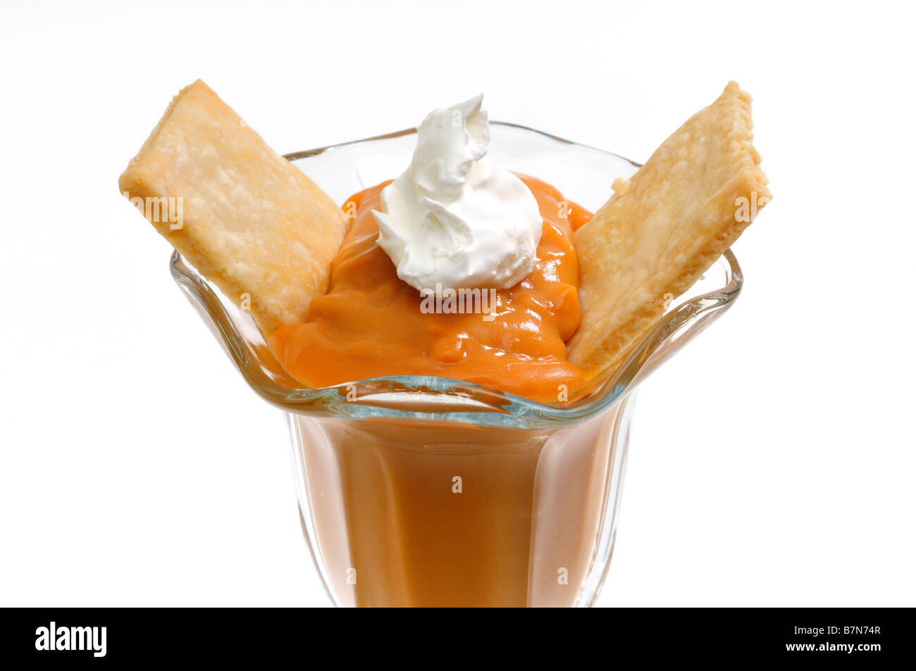 A serving of butterscotch pudding with pastry squares and whipped cream ...