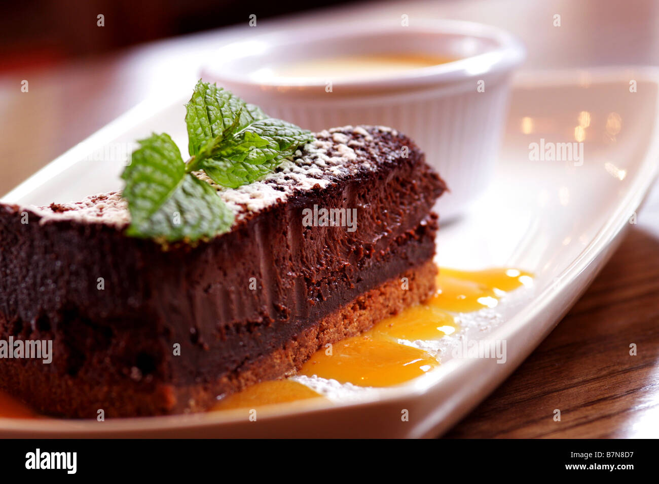 Belgian Chocolate Cheesecake with orange coulis on a white plate Stock ...