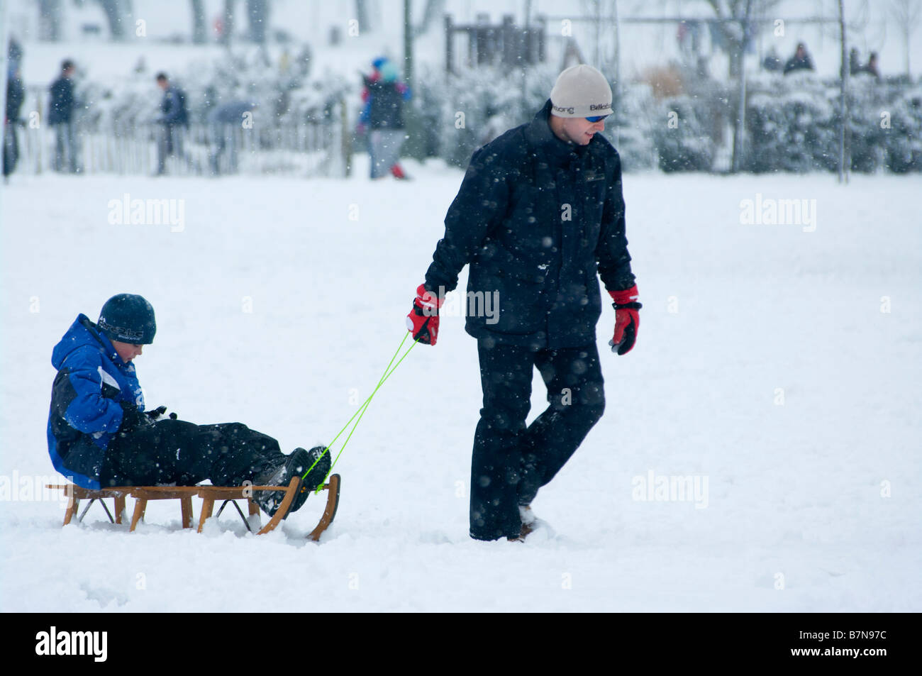 Man pulling boy on sledge hi-res stock photography and images - Alamy