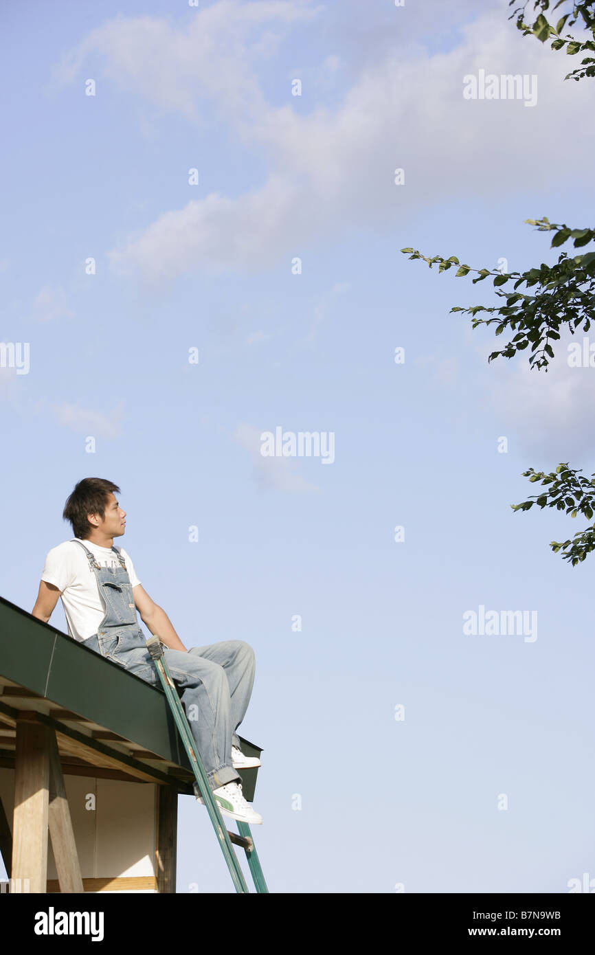 A man sitting on the roof Stock Photo - Alamy