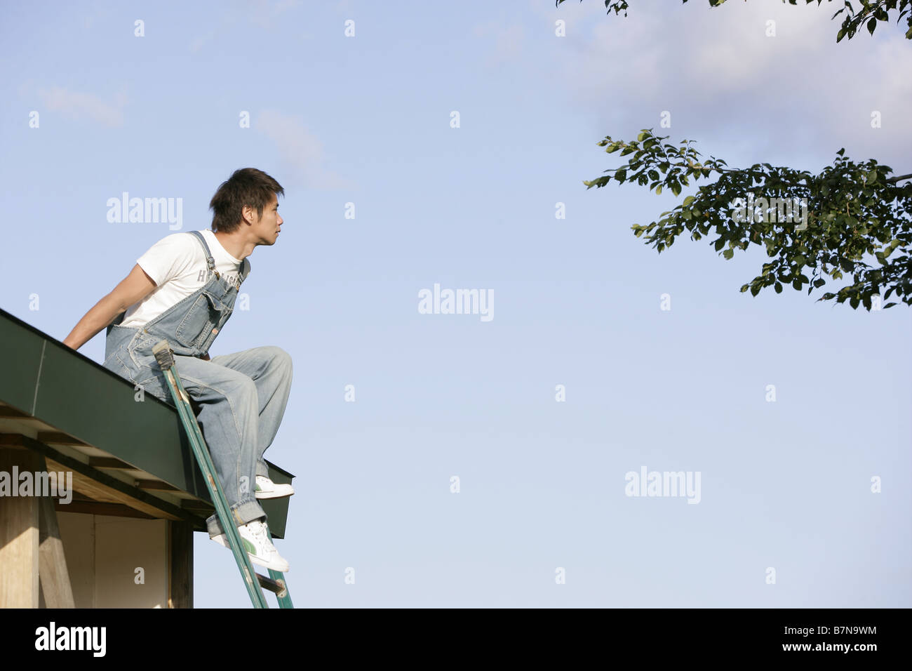 A man sitting on the roof Stock Photo - Alamy