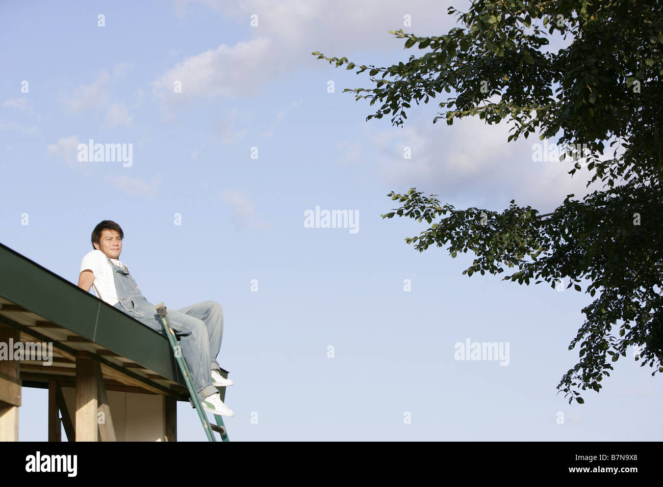 A man sitting on the roof Stock Photo - Alamy