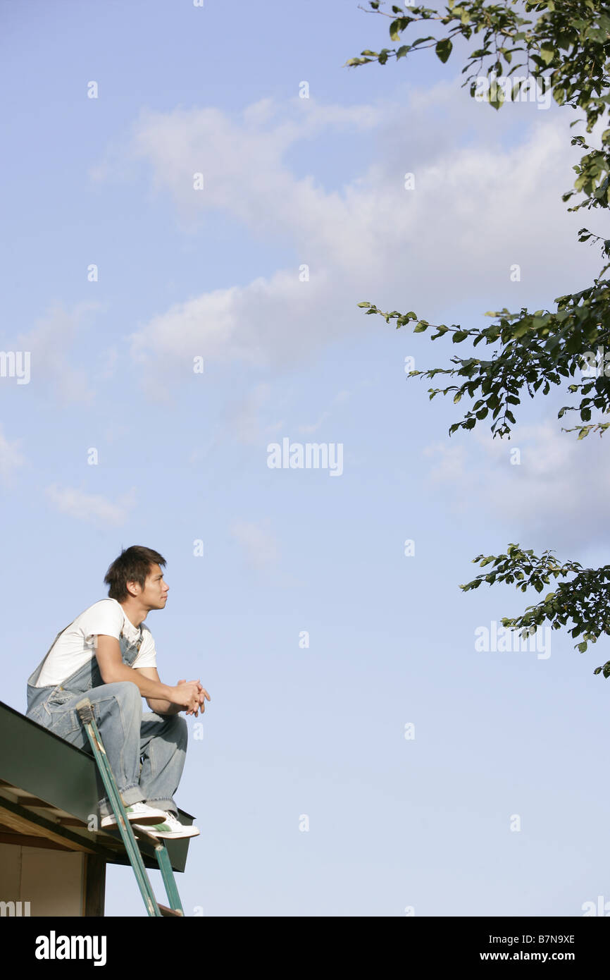 A man sitting on the roof Stock Photo - Alamy