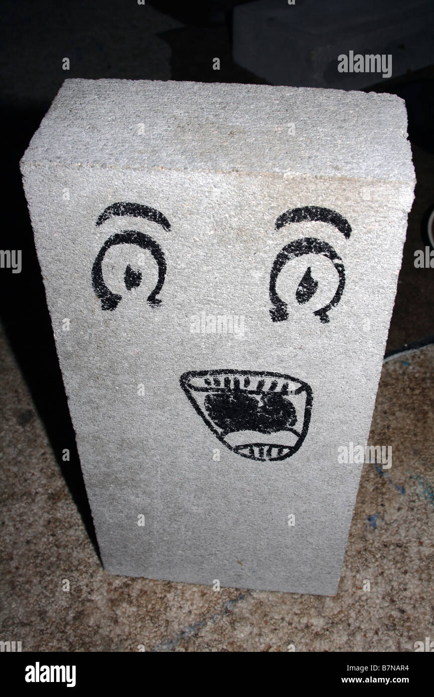 Smiling face on cinderblock, vertical Stock Photo - Alamy