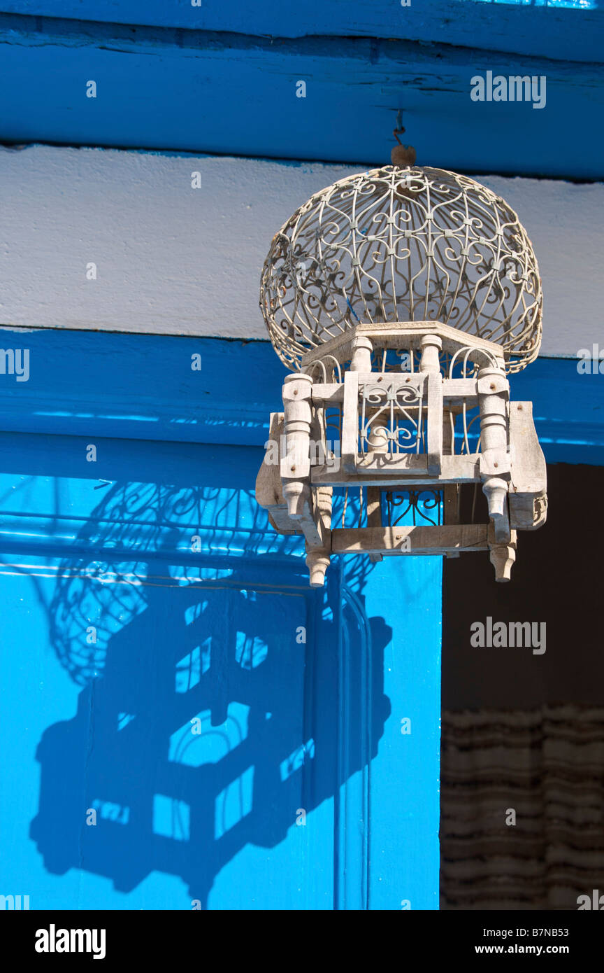 Ornamental bird cage with shadow against blue and white background in ...