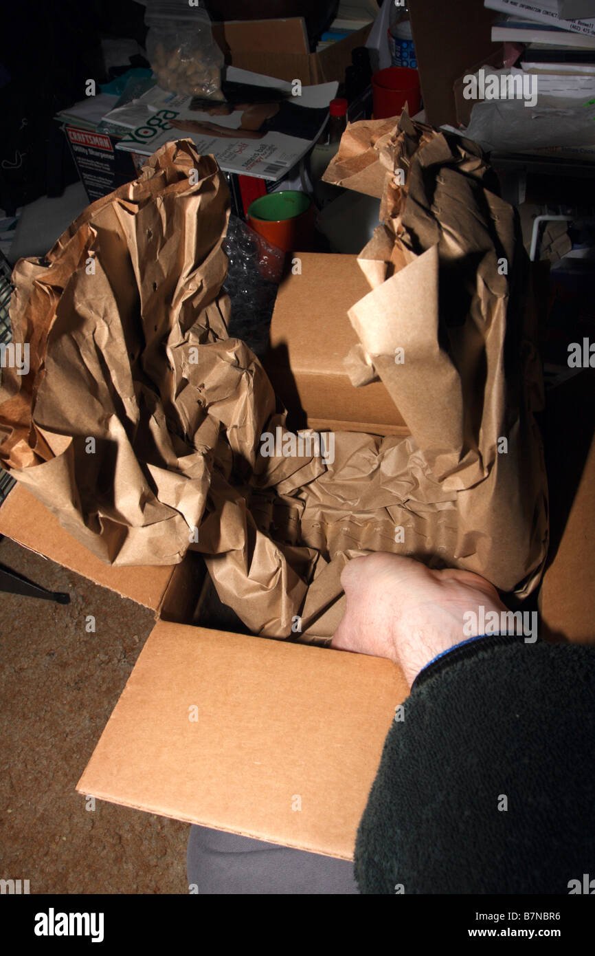 Hand inside cardboard box with splaying packing material Stock Photo ...