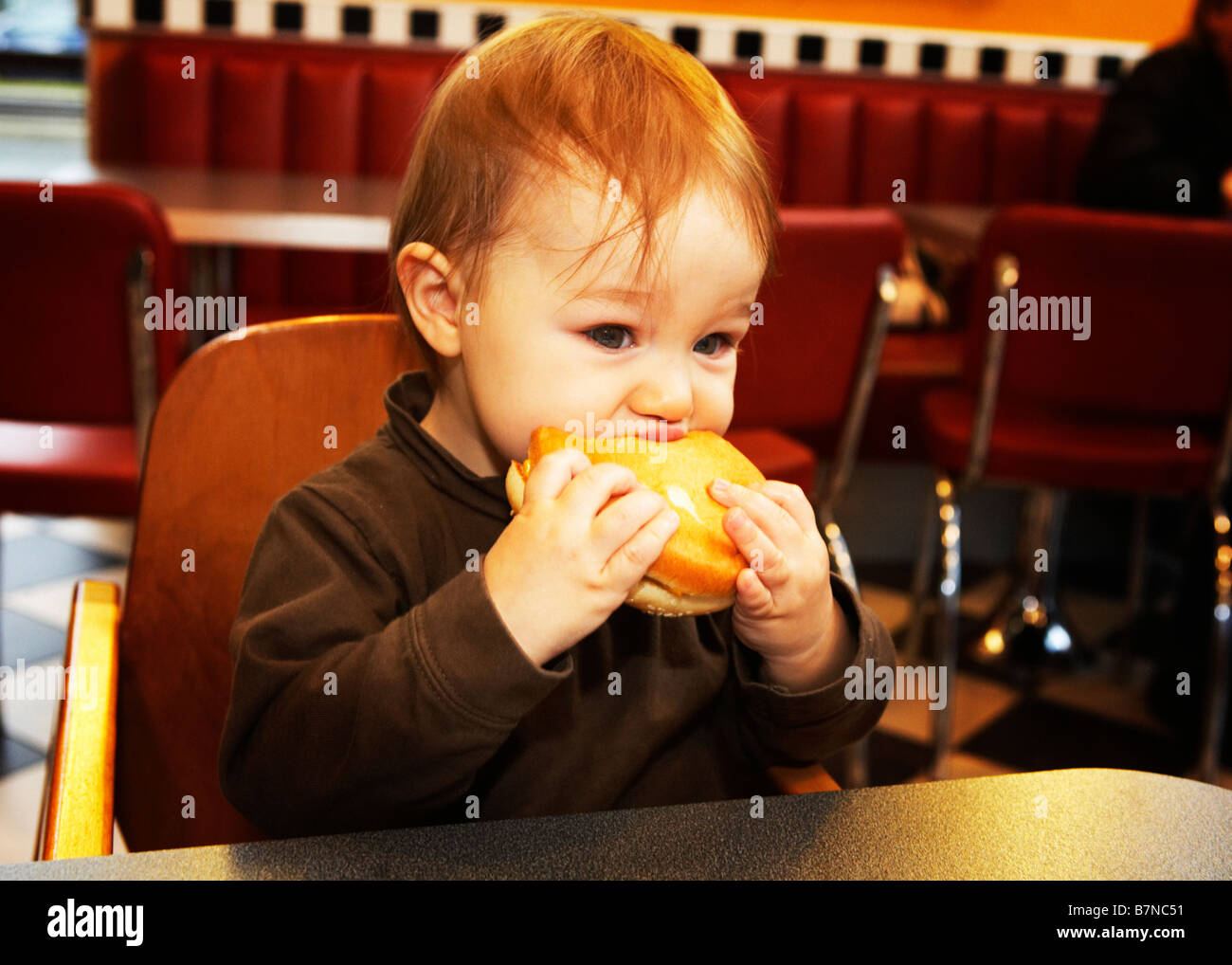 Child (15 month) old eating first Hamburger ever in a Hamburger ...