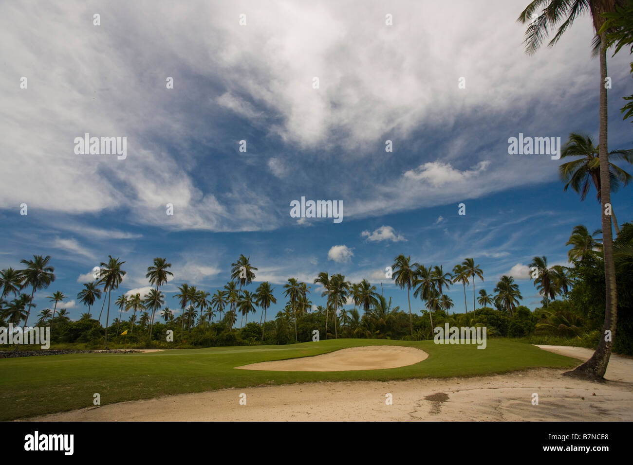 Cloudy sky above palm-fringed golf course with sandy bunker in Brazil ...