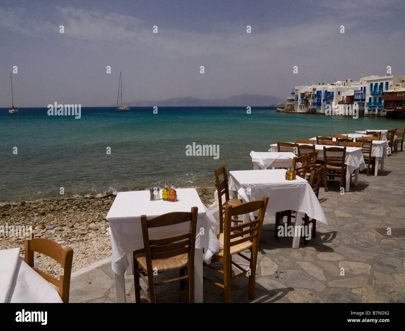 Tables and chairs with an ocean view, Greek Islands, Greece Stock Photo ...