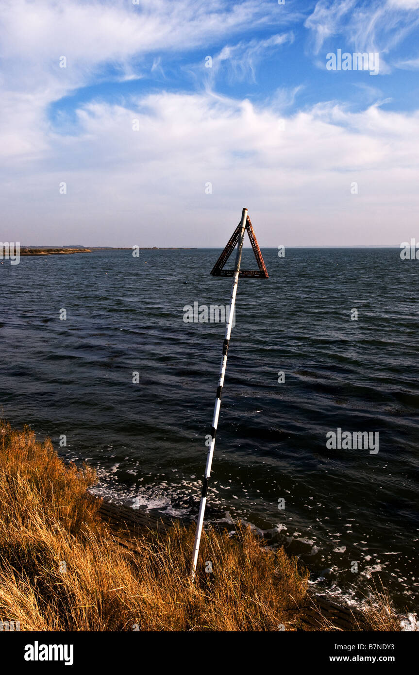 A hazard warning pole on the sea wall of the Blackwater Estuary in ...