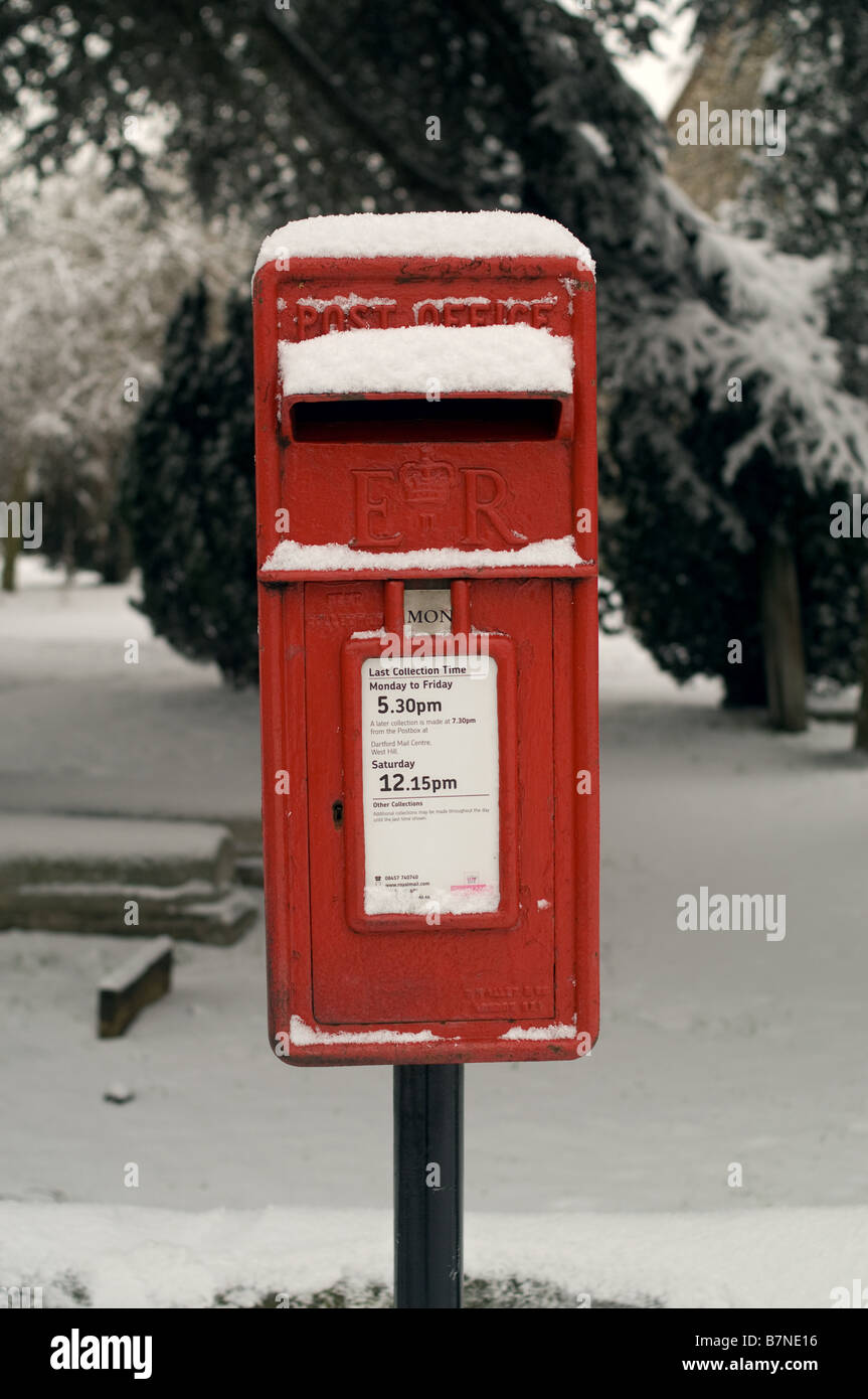 Snow covered post box, trees and churchyard in background Stock Photo ...