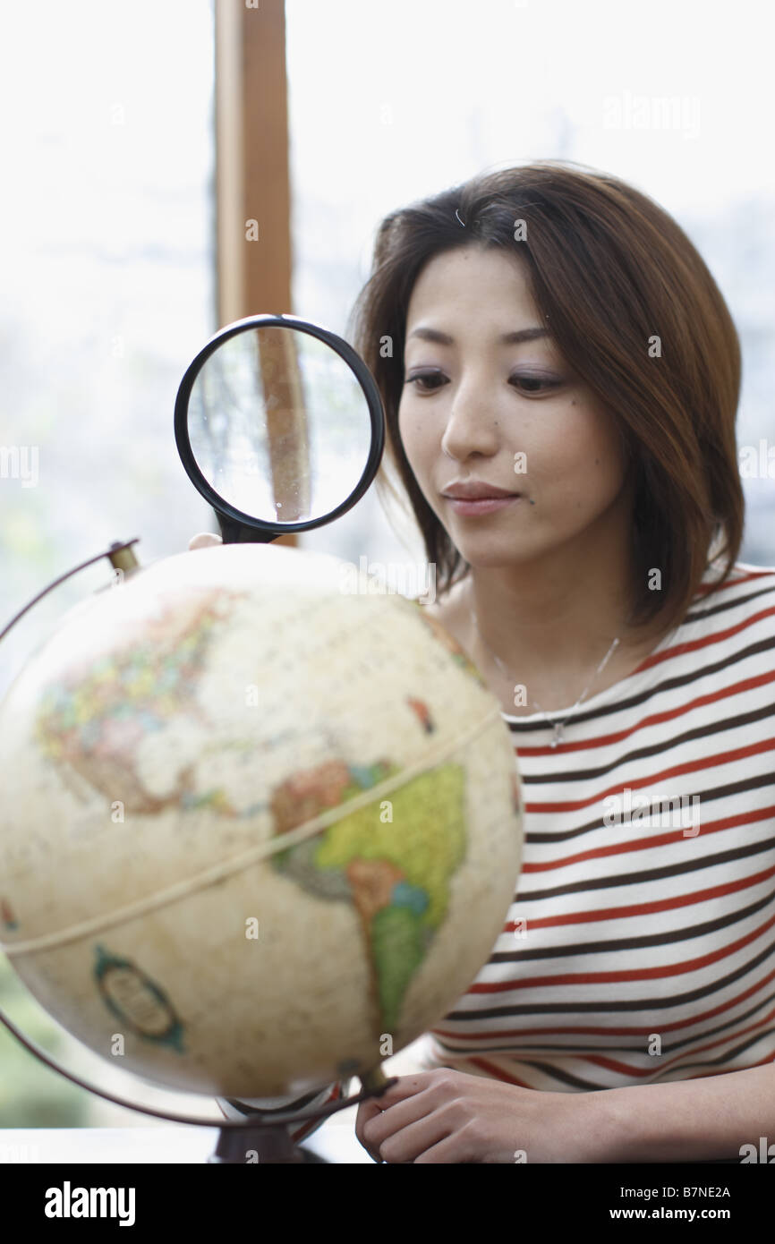Woman looking at globe Stock Photo - Alamy