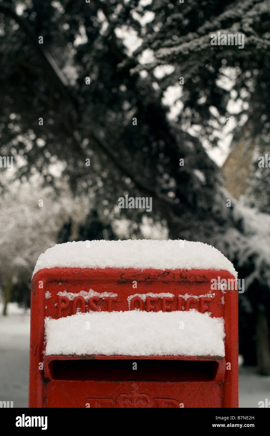 Snow covered post box, trees in background Stock Photo - Alamy