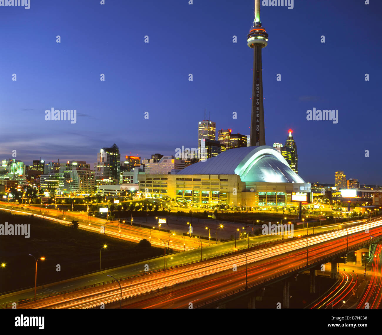 Toronto at dusk with CN Tower and Skydome and motion on the highway ...