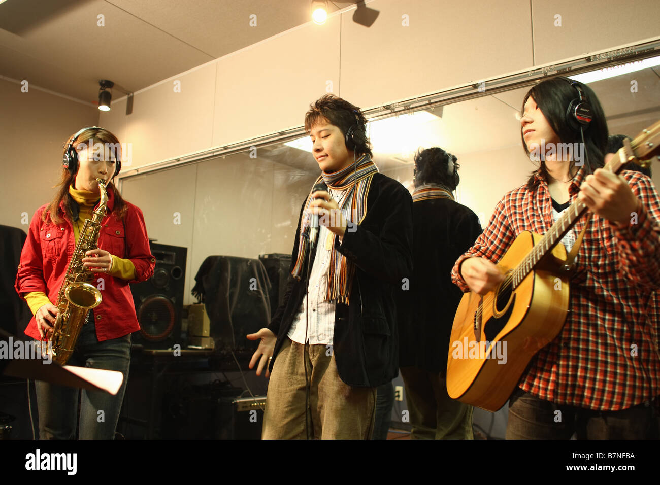 Young people playing instruments in recording stadio Stock Photo - Alamy