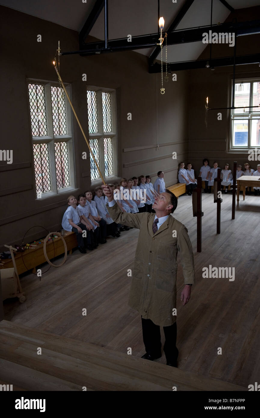 Children experince life in a Victorian School. A man lights a gads lamp ...
