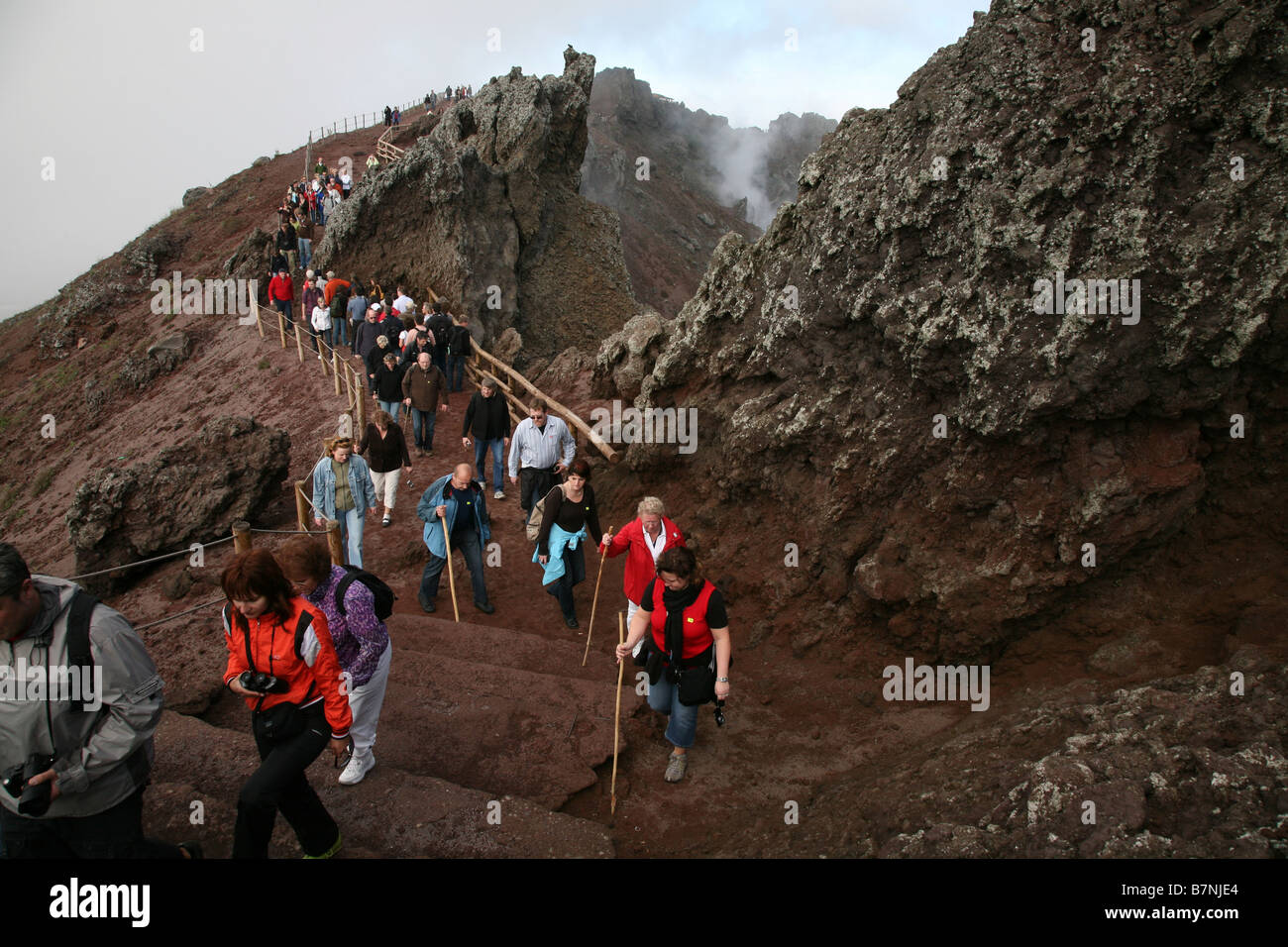 Tourists walk by the rim of the crater of Mount Vesuvius in Campania ...